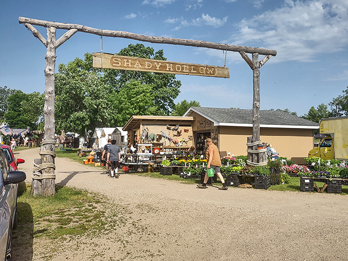 The rustic entrance to Shady Hollow welcomes treasure hunters with a handcrafted sign that practically whispers, "Abandon all budgets, ye who enter here."