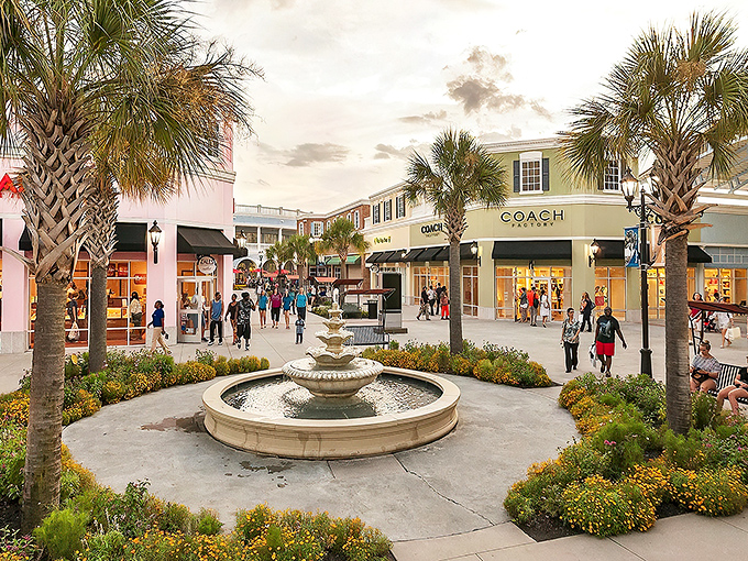 Palm trees frame the coastal-inspired architecture of Tanger Outlets Charleston, where fountains and flowers create shopping ambiance that's distinctly Southern.