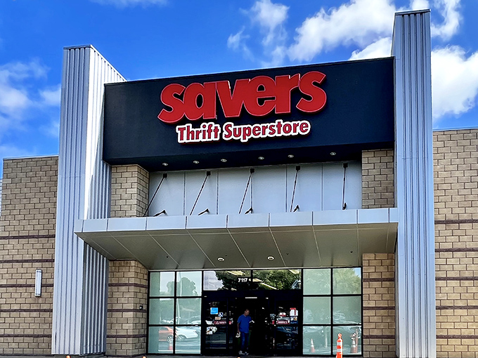 The bold red Savers sign against a blue sky promises treasure hunting adventures within &ndash; like a theme park for bargain enthusiasts where the admission is free but the memories are priceless.