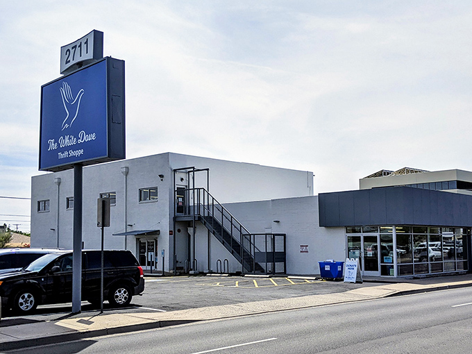 The iconic blue sign of White Dove Thrift Shoppe stands like a retail lighthouse, beckoning bargain hunters to this Phoenix treasure trove of second chances.