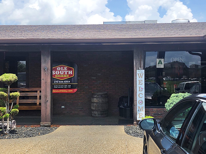 A welcoming sight that says "come on in" - Ole South's entrance features classic brick, a wooden barrel, and that iconic sign beckoning barbecue pilgrims.