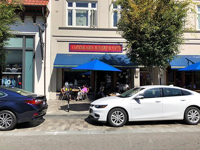 Blue awnings and outdoor seating create the perfect backdrop for people-watching while savoring a slice of European caf&eacute; culture.