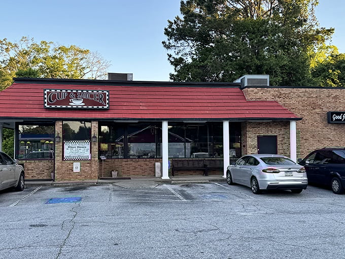 The iconic red awning of Cup & Saucer beckons like a lighthouse for hungry souls navigating the sea of chain restaurants in Loganville.