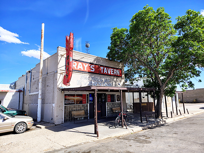 The iconic red neon sign of Ray's Tavern stands like a desert lighthouse, guiding hungry travelers to burger paradise since the 1940s.