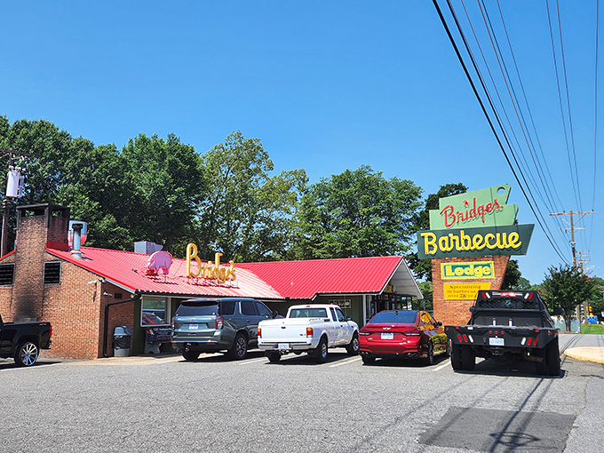The iconic red-roofed Bridges Barbecue Lodge stands like a barbecue beacon in Shelby, its vintage neon sign promising smoky delights within.