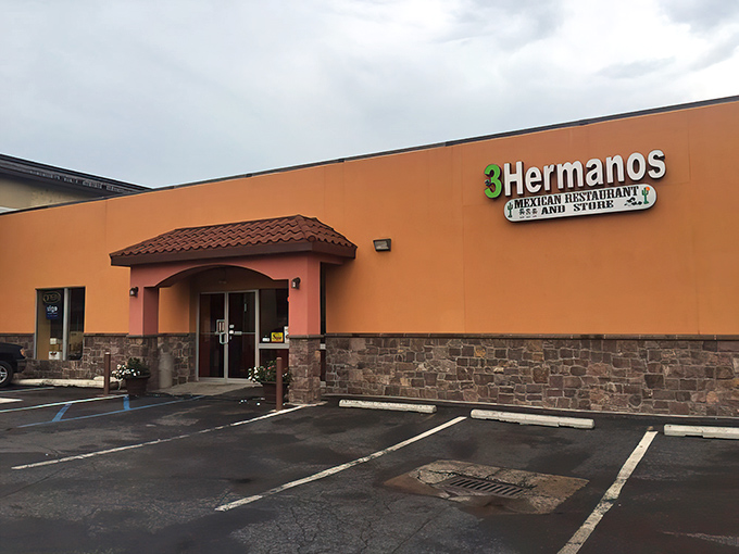 The bright orange exterior of Tres Hermanos stands out like a culinary beacon, promising authentic Mexican flavors in suburban Harrisburg.