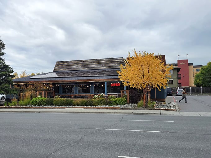 Fall in Alaska brings golden foliage to match Spenard Roadhouse's welcoming blue exterior. The perfect backdrop for culinary adventures ahead.