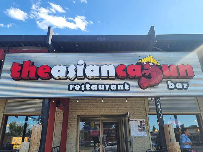 The Asian Cajun's storefront promises a culinary adventure with its playful red crab logo. Like finding a treasure map in Denver's urban landscape.