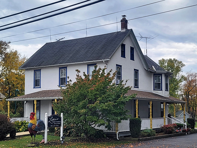 The full view reveals what looks like your favorite aunt's house, complete with wraparound porch and a rooster sign that promises comfort before you even step inside.