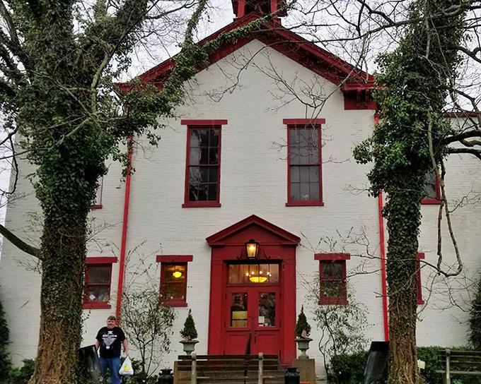 History and ivy embrace this former schoolhouse like old friends at a reunion. The red trim and white brick say "America" louder than a Fourth of July parade.