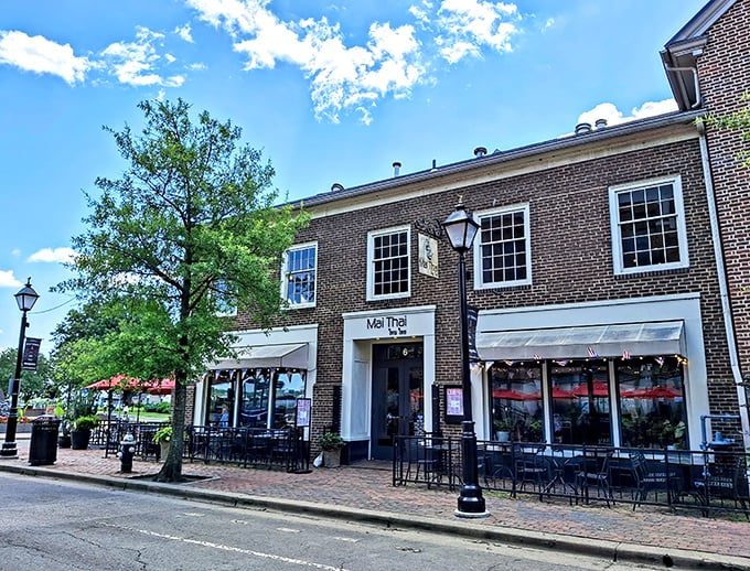 The charming brick fa&ccedil;ade of Mai Thai beckons from Old Town Alexandria's historic streets, promising culinary adventures behind those welcoming red awnings.