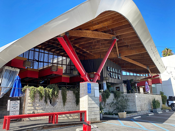 The wave-like roof and bold red supports of Connie and Ted's aren't just architectural showmanship—they're your first clue that seafood magic awaits inside.