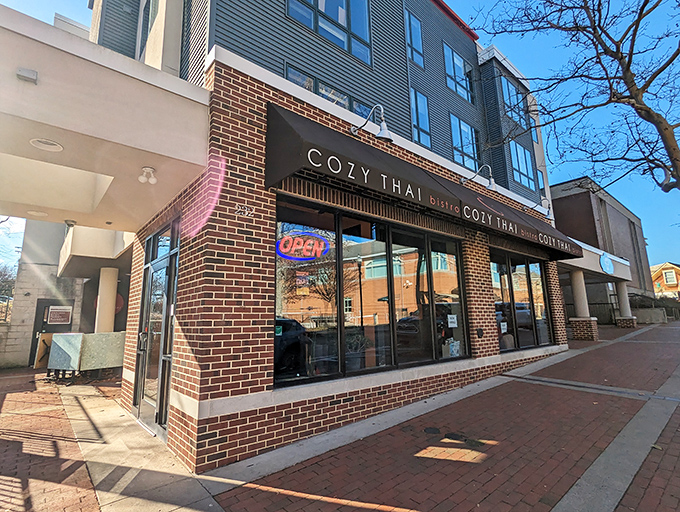 Nestled between modern buildings on a brick-paved sidewalk, Cozy Thai's welcoming "OPEN" sign might as well say "Flavor Nirvana This Way."