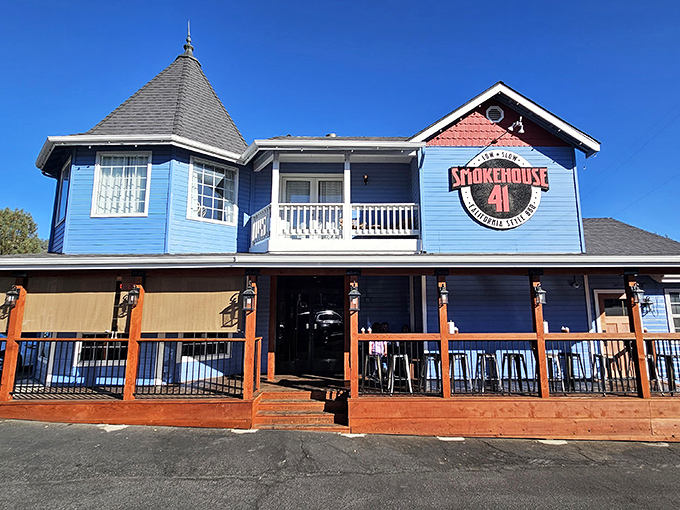 The blue Victorian-style exterior of Smokehouse 41 stands out like a barbecue oasis in Oakhurst, promising smoky treasures within its charming turret and wooden deck.