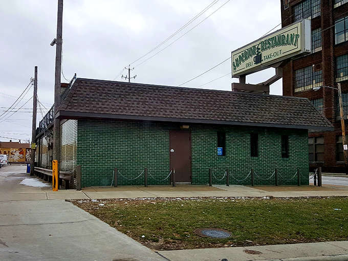 The unassuming green brick exterior of Superior Restaurant stands like a culinary fortress, promising treasures within that fancy facades could never deliver.