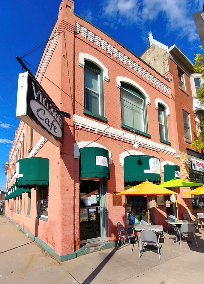The coral-brick facade with emerald awnings isn't just charming&mdash;it's a beacon for hungry travelers. This corner of Baraboo promises culinary surprises behind that vintage sign.