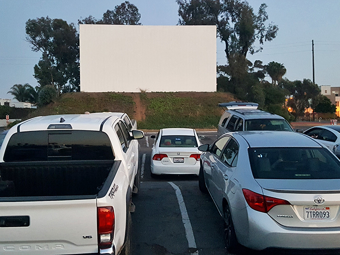 The classic white screen against the twilight sky &ndash; cinema in its most elemental form, where stories unfold under the stars.