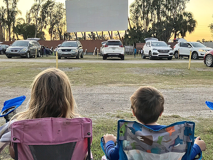 Cars lined up at dusk, their silhouettes framed against the massive white screen&mdash;cinema's most honest relationship with the Florida sunset.