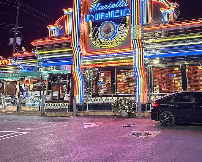 The neon rainbow exterior of Marietta Diner at night isn't just a restaurant sign&mdash;it's a beacon calling hungry souls home at any hour.