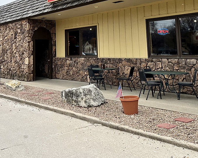 Stone and wood exterior welcomes hungry patrons with a touch of roadside charm. The small outdoor seating area offers a spot to enjoy Nebraska's pleasant days.