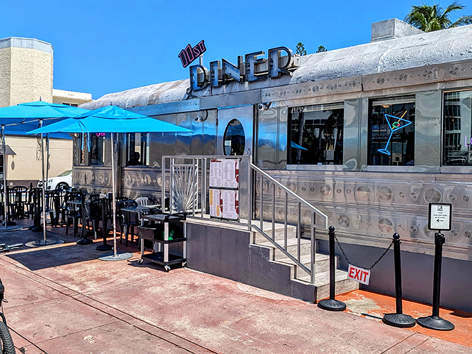 The gleaming silver exterior of 11th Street Diner shines under Miami Beach's blue sky, a chrome time capsule serving nostalgia with a side of sunshine.