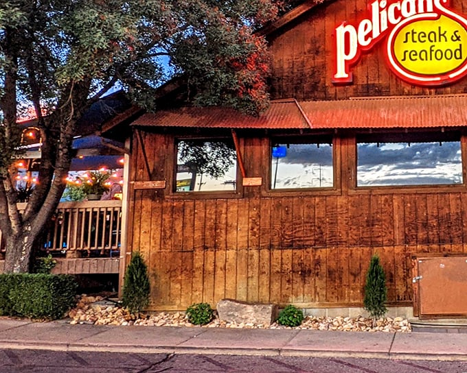 The rustic wooden exterior of Pelican's glows at dusk, a maritime mirage in the desert that promises oceanic treasures within.