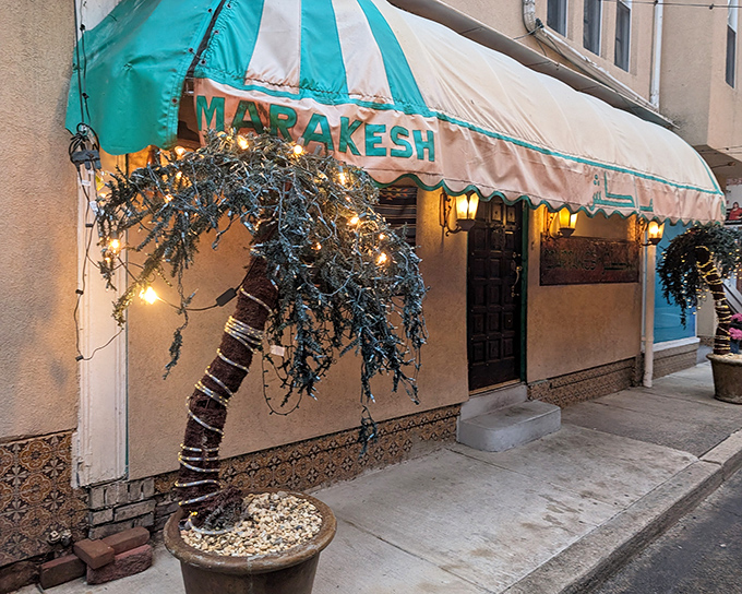 The turquoise and white striped awning of Marrakesh beckons like a mirage in Philadelphia, complete with decorative palm trees that whisper promises of exotic flavors within.