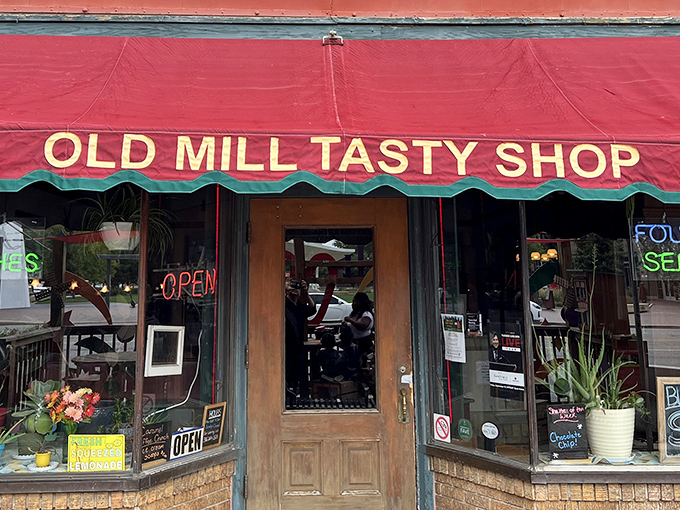 The iconic red awning of Old Mill Tasty Shop beckons like a culinary lighthouse, promising comfort food treasures within downtown Wichita's bustling streets.