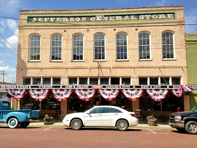 The historic façade of Jefferson General Store stands proudly on brick streets, complete with patriotic bunting and that picture-perfect blue vintage pickup truck.
