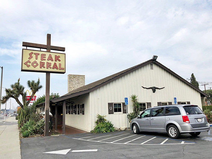 That iconic sign beckons like a beacon of beef salvation on Whittier Boulevard. The white building with its longhorn skull promises carnivorous delights within.