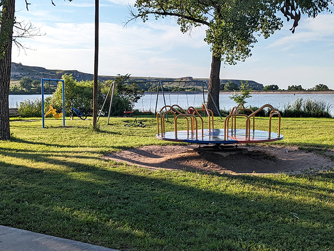 Childhood nostalgia meets natural splendor at Lake Scott's playground area, where kids can swing while parents soak in those million-dollar bluff views.