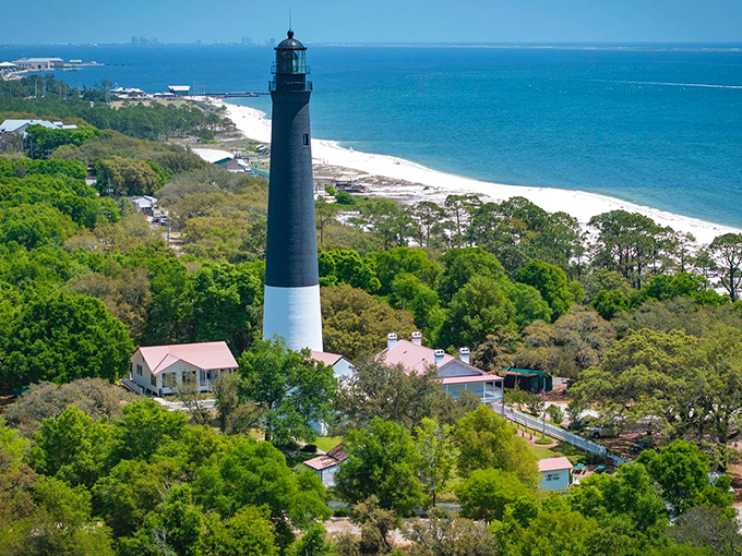 The iconic black and white tower rises majestically against Florida's blue sky, standing sentinel over Pensacola Bay since 1859.