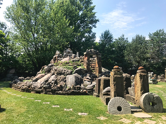 The centerpiece of this backyard wonderland rises like a miniature mountain range, complete with stone pillars that seem to defy both gravity and conventional landscaping wisdom.