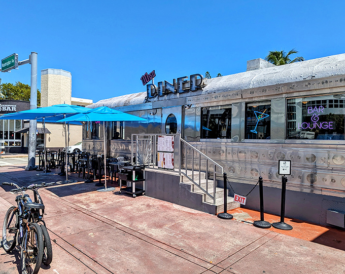 The gleaming silver exterior of 11th Street Diner stands like a time machine in Miami Beach, beckoning hungry time travelers with its classic Art Deco charm.
