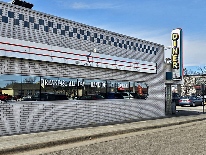 The classic white-tiled exterior with its bold neon "DINER" sign isn't just advertising &ndash; it's a promise of American comfort food perfection waiting inside.