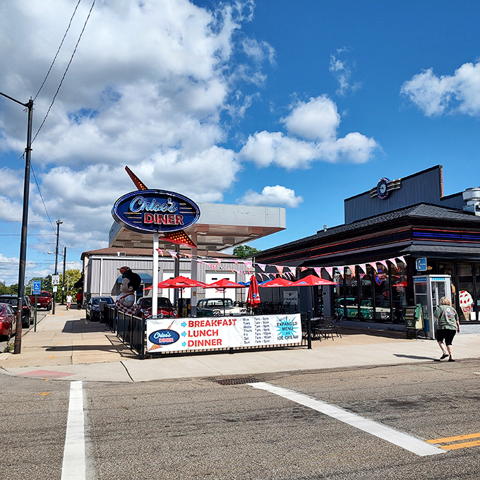 That neon sign isn't just advertising&mdash;it's a time portal disguised as a diner. The red umbrellas practically wink at you from the sidewalk.