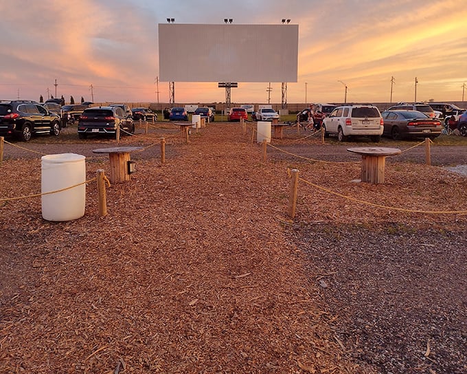 Sunset magic at Quasar Drive-In, where cars gather like faithful pilgrims to worship at the altar of cinema under Nebraska's painted sky.