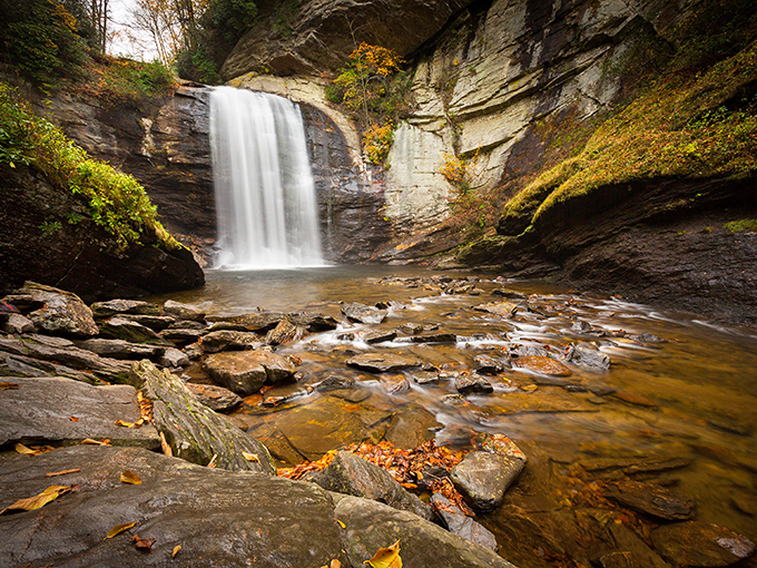 Nature's own silk curtain, cascading 60 feet down ancient rock faces. The vibrant spring greenery frames this masterpiece like a living gallery.