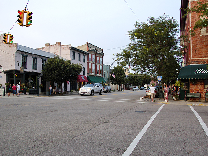 Main Street magic in full display &ndash; historic storefronts, vintage lampposts, and locals gathering on benches create the quintessential small-town tableau.