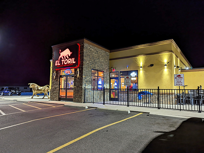 El Toril's glowing bull sign welcomes hungry travelers like a beacon of hope in the night. The stone and stucco exterior promises authentic flavors within.