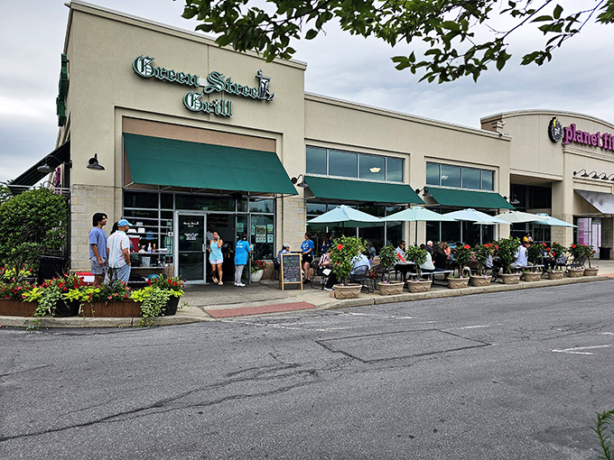 Green Street Grill's inviting exterior promises culinary adventures with its cheerful green awnings and flower-filled patio seating. Breakfast paradise awaits!