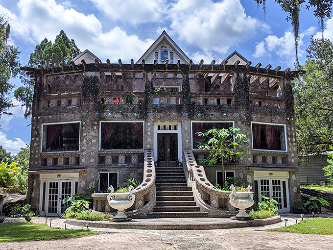 The grand entrance to Wonder House feels like the prologue to a fairytale, with its shell-studded facade and symmetrical staircase inviting exploration.