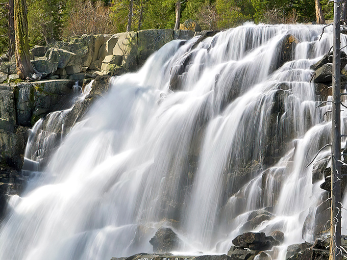 Nature's own silk curtain cascades over ancient granite, creating a hypnotic display that makes even the most jaded hikers stop in their tracks.
