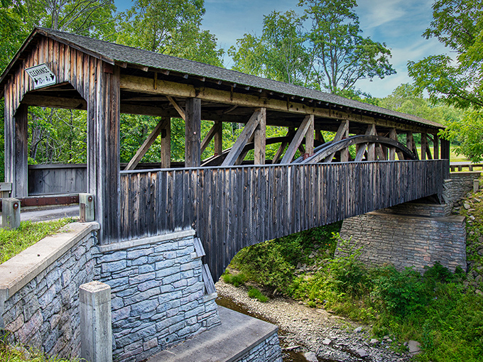 Sunlight dances across the bridge's timbers on a perfect summer day, showcasing the craftsmanship that's outlasted countless modern structures.