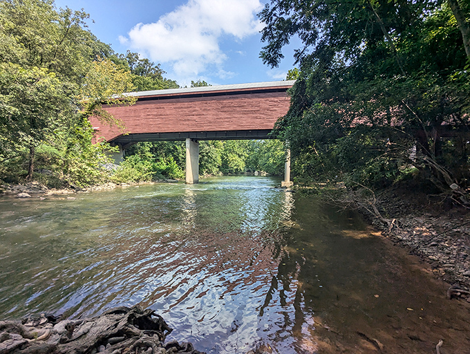 The rustic red exterior of Meem's Bottom Covered Bridge stands in striking contrast to the lush greenery, like a barn-colored exclamation point in nature's paragraph.
