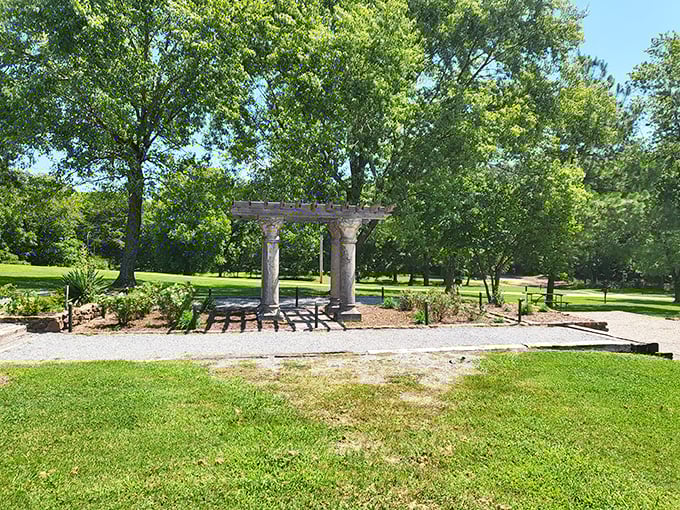 Stone columns and a pergola create a peaceful gathering spot amid lush greenery, offering visitors a moment of Zen before exploring the park's natural wonders.