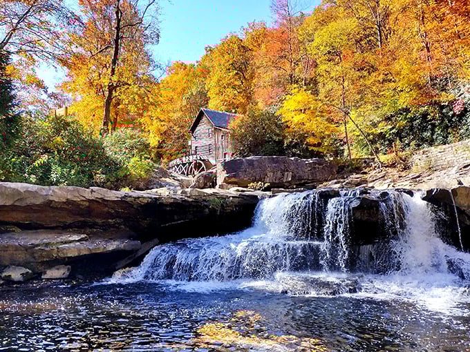 Nature's perfect postcard moment: the iconic Glade Creek Grist Mill framed by autumn's fiery palette and the soothing cascade of mountain waters.