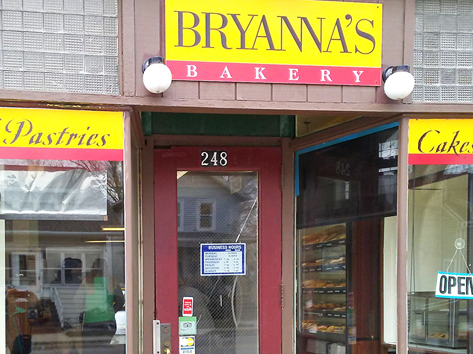 The bright yellow sign of Bryanna's Bakery stands out like a beacon of sweetness on Main Street, promising pastry perfection behind that unassuming brick facade.