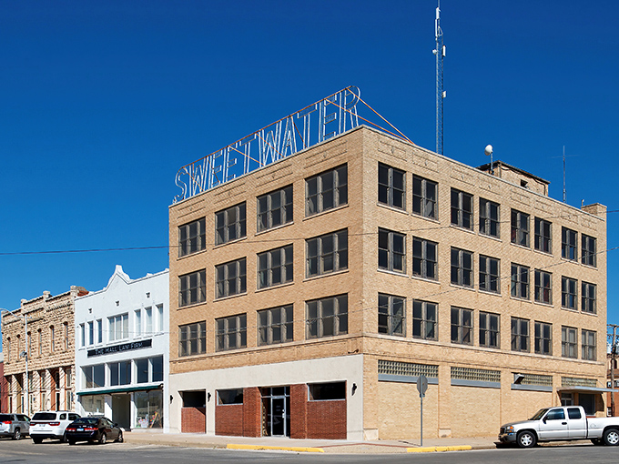 The iconic Sweetwater sign stands tall against that impossibly blue Texas sky, like a beacon calling weary travelers home.