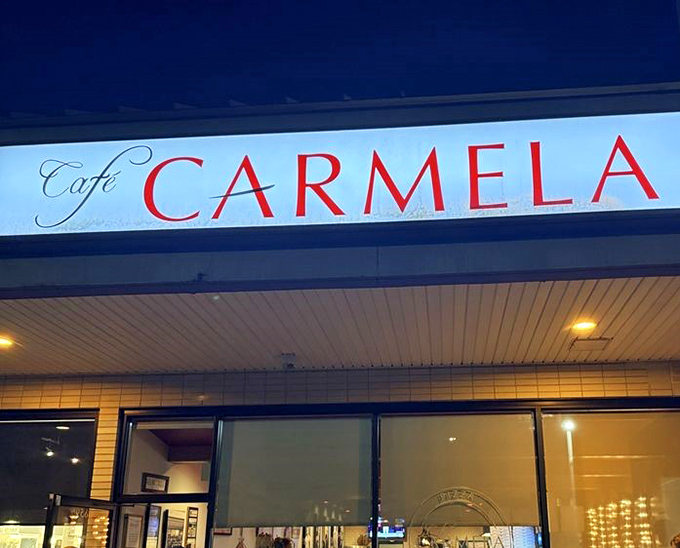 The red lettering of Cafe Carmela glows like a beacon for hungry travelers. Philadelphia's hidden Italian gem awaits your appetite.